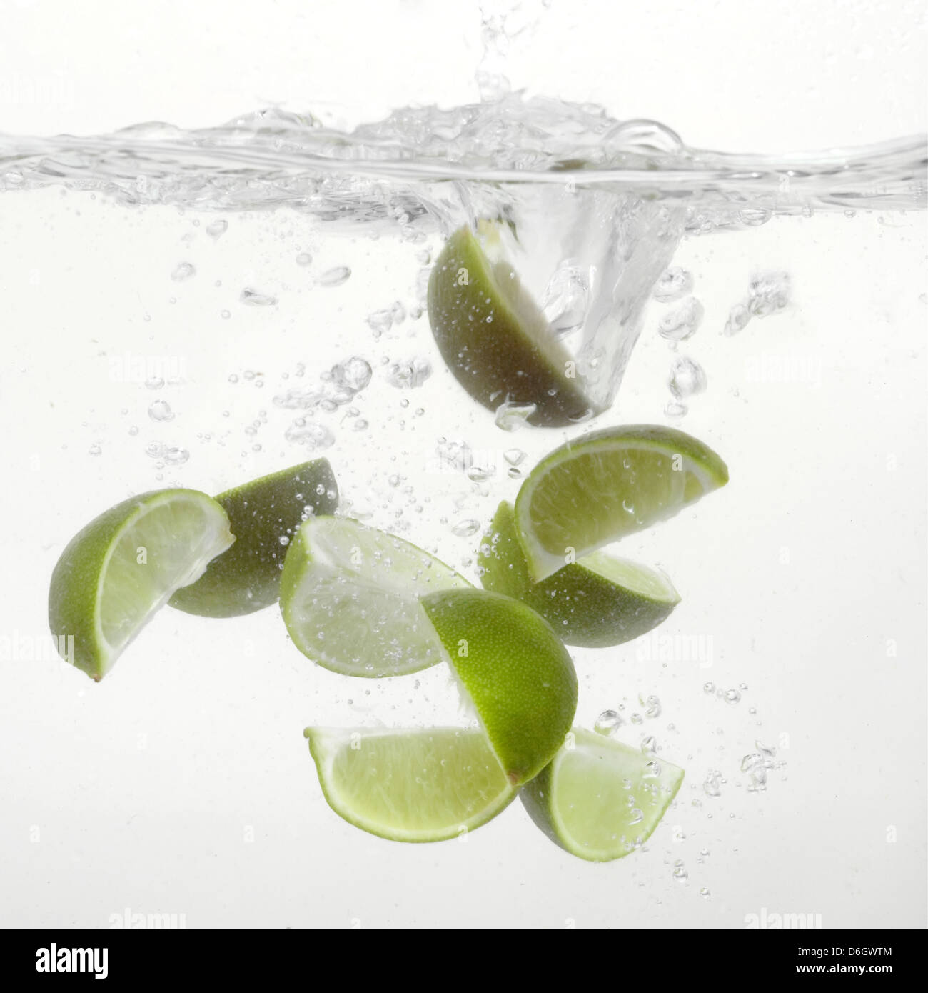 Lime wedges splashing into water Stock Photo - Alamy
