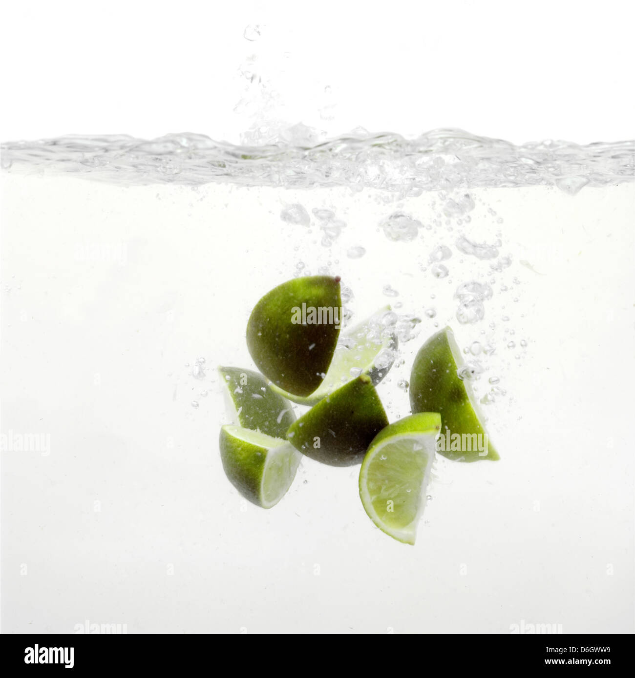 Lime Wedges splashing into water Stock Photo - Alamy