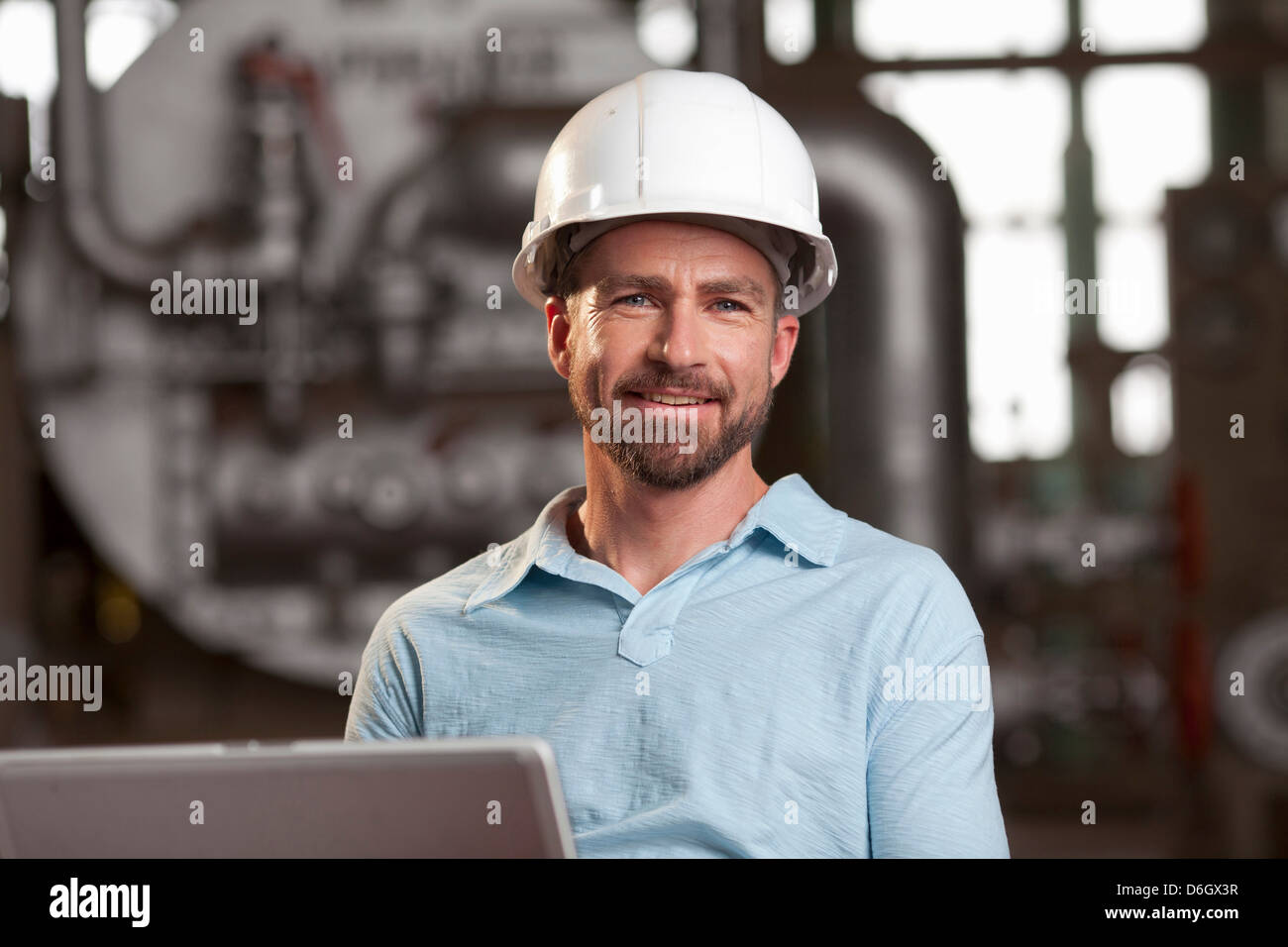 Industrial worker using laptop Stock Photo - Alamy