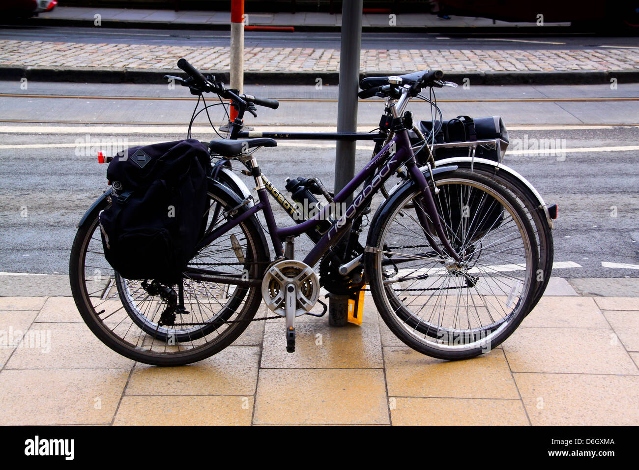 Bikes chained to post in city street Stock Photo - Alamy