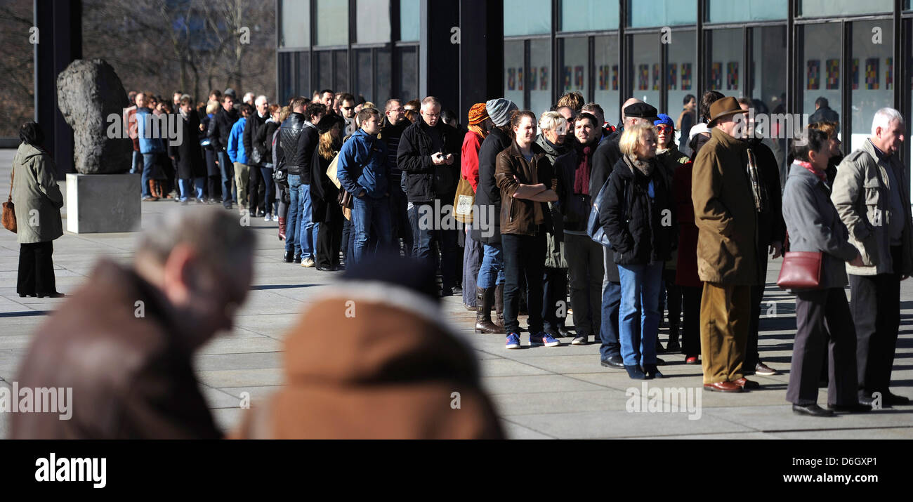 Visitors stand in line in front of the New National Gallery and wait to ...
