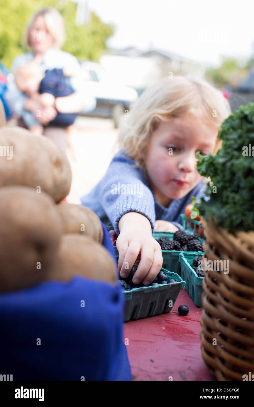 Boy eating fruit at farmer's market Stock Photo - Alamy