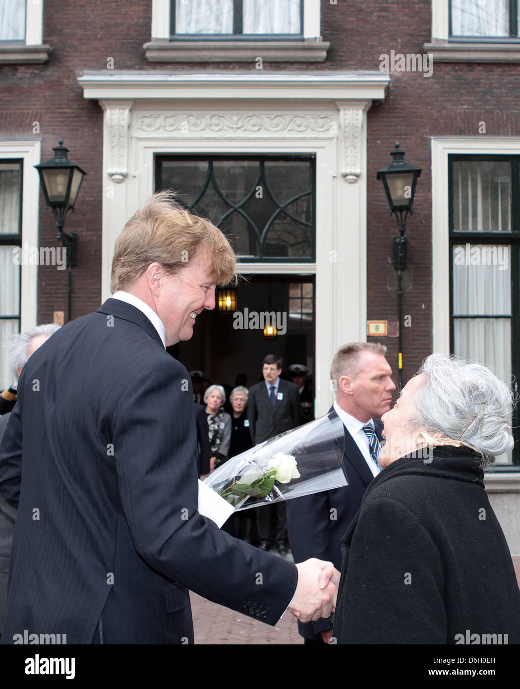 Dutch Crown Prince Willem-Alexander receives a white rose from a woman ...