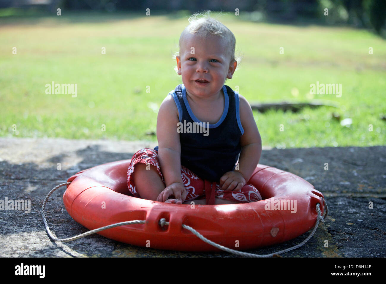 Baby boy sitting in life preserver Stock Photo - Alamy
