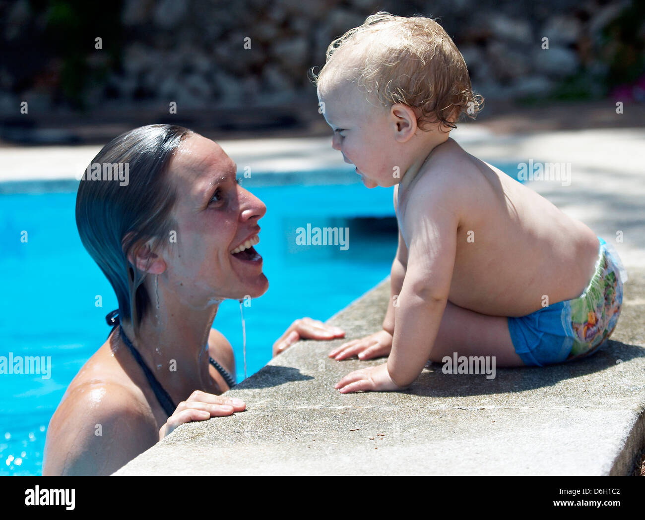 Mother and baby by swimming pool Stock Photo - Alamy