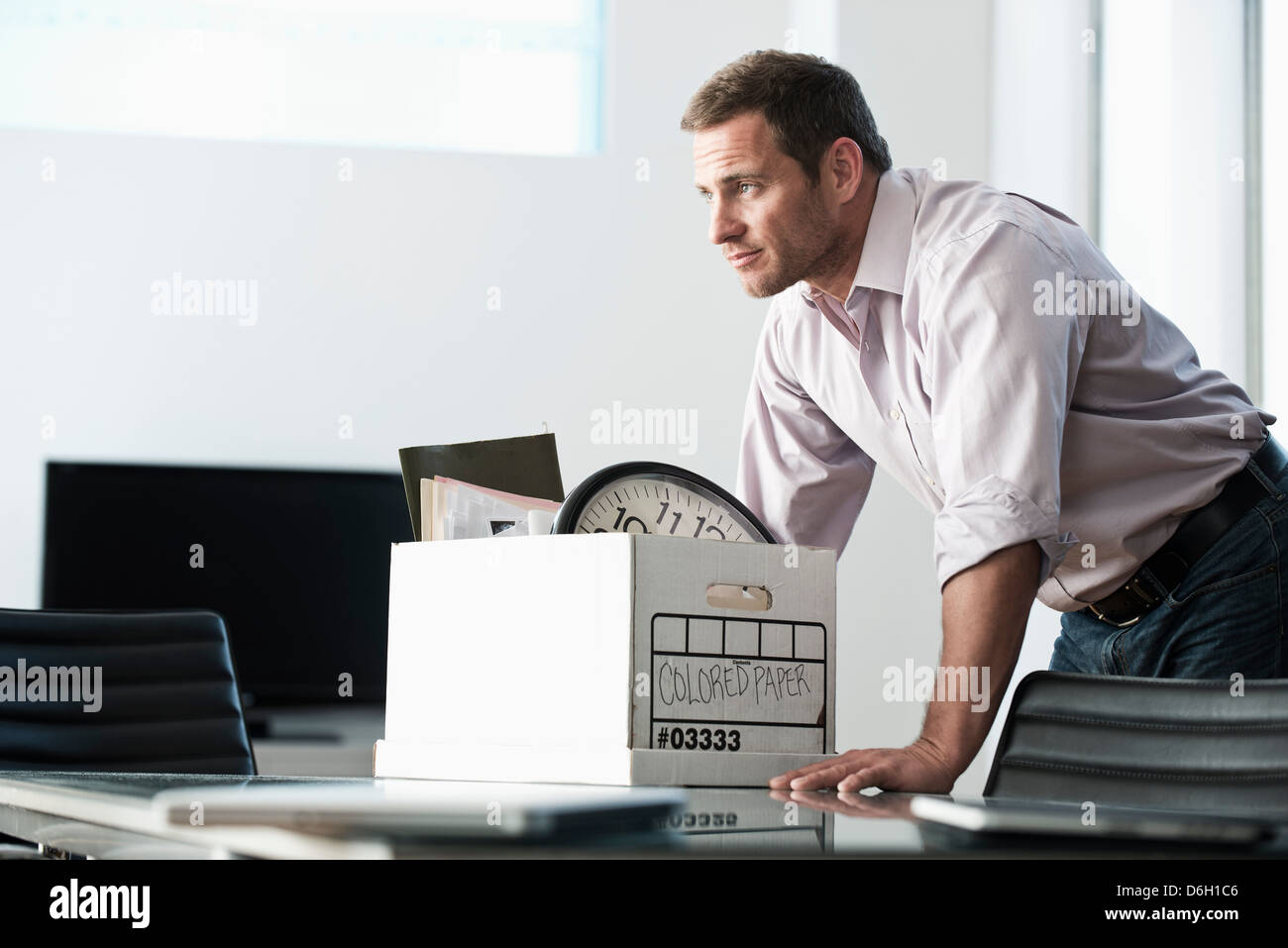 Businessman packing up box in office Stock Photo - Alamy