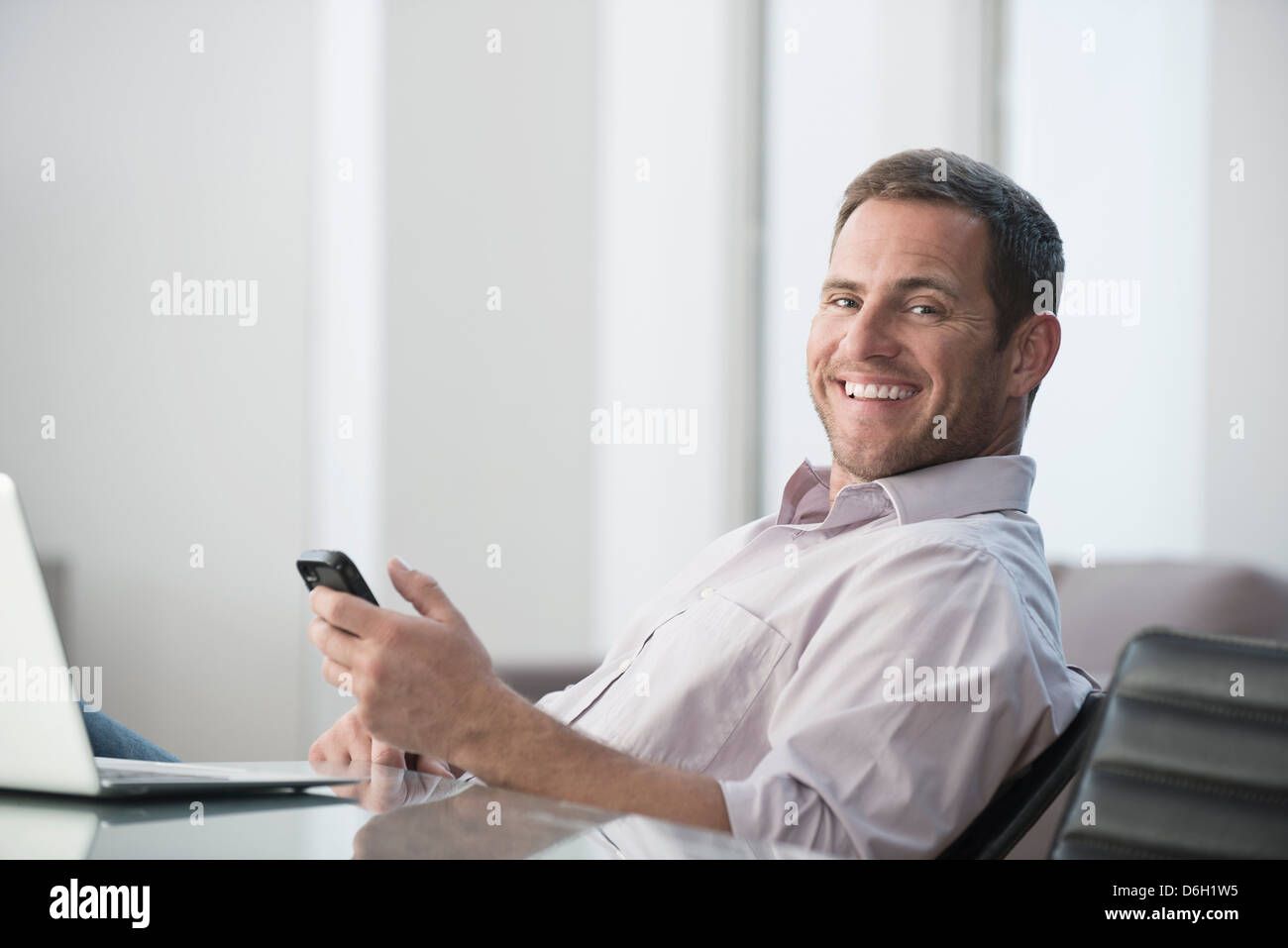 Businessman using cell phone at desk Stock Photo - Alamy