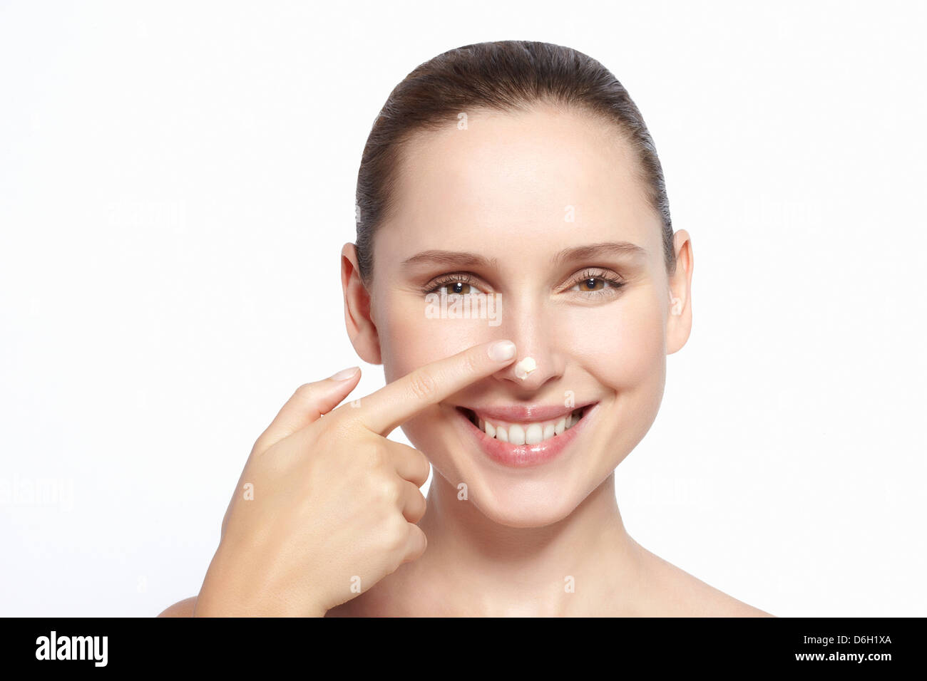 Woman rubbing moisturizer on face Stock Photo - Alamy