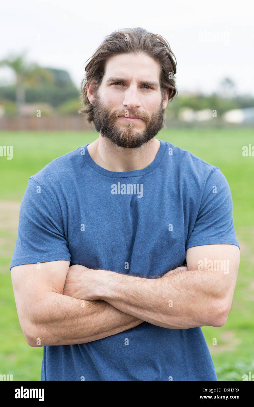 Man standing with arms crossed outdoors Stock Photo - Alamy