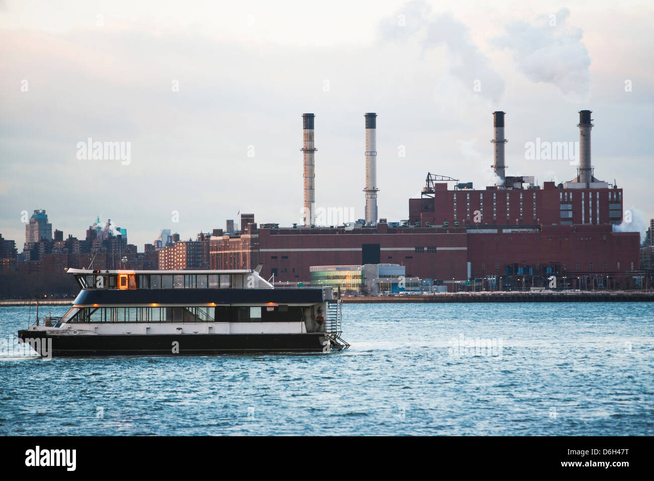 Boat sailing in urban harbor Stock Photo - Alamy