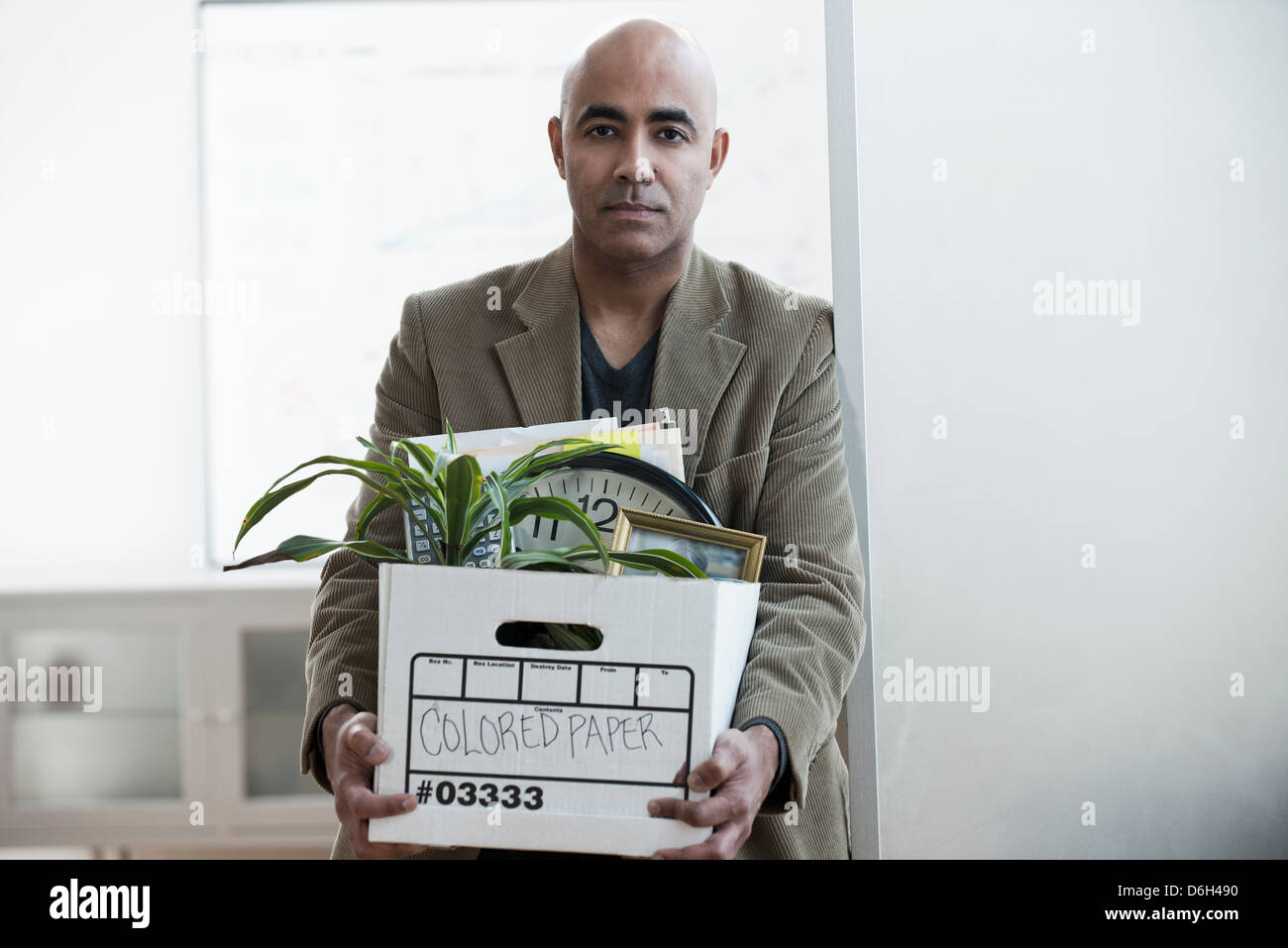 Businessman packing up box in office Stock Photo - Alamy