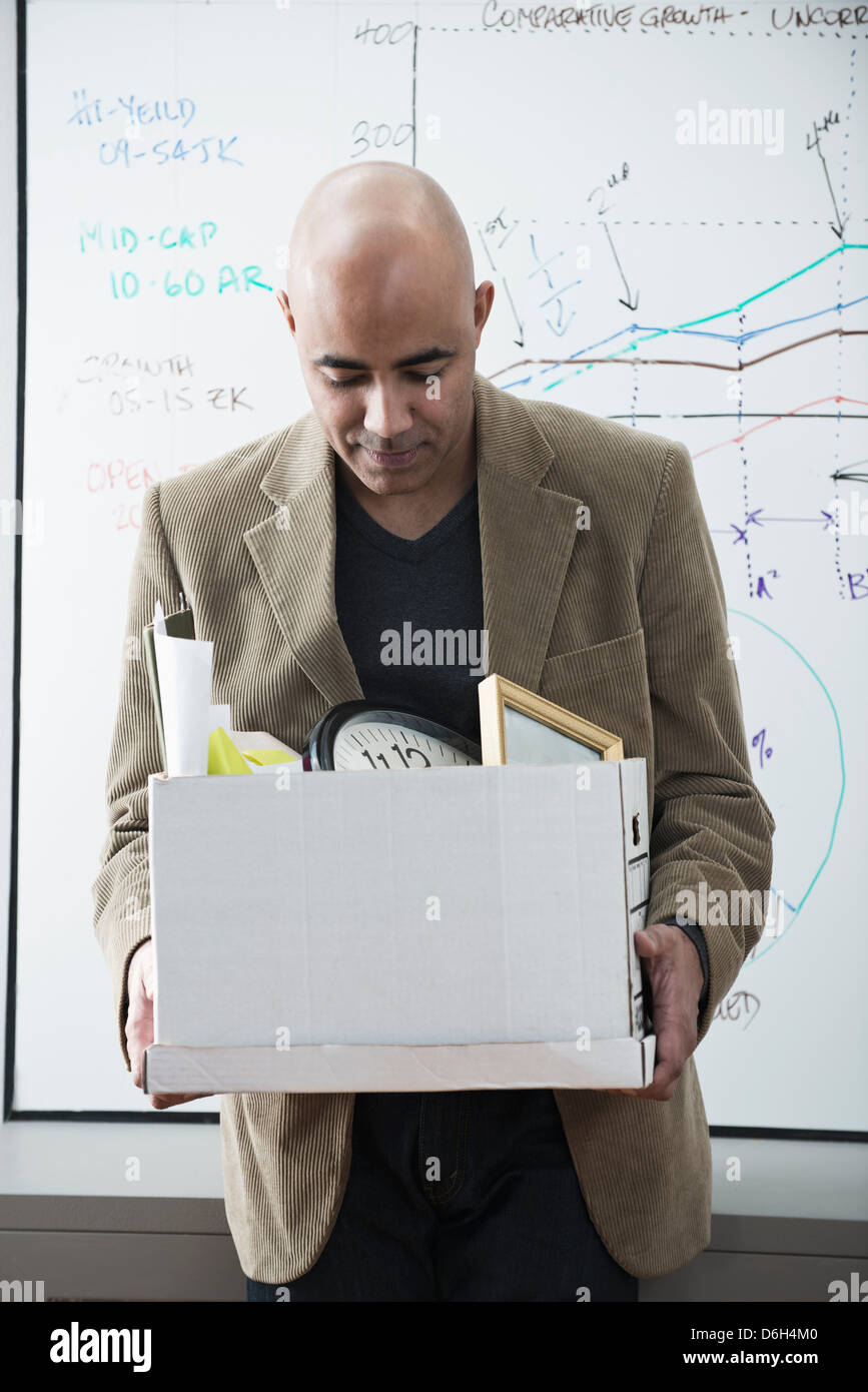 Businessman packing up box in office Stock Photo - Alamy
