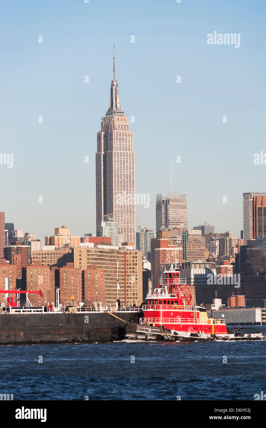 Barge floating by New York City skyline Stock Photo - Alamy