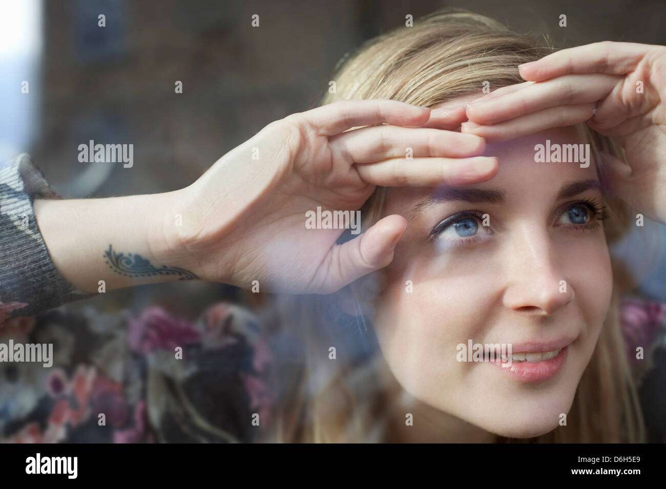 Woman peering through window Stock Photo - Alamy