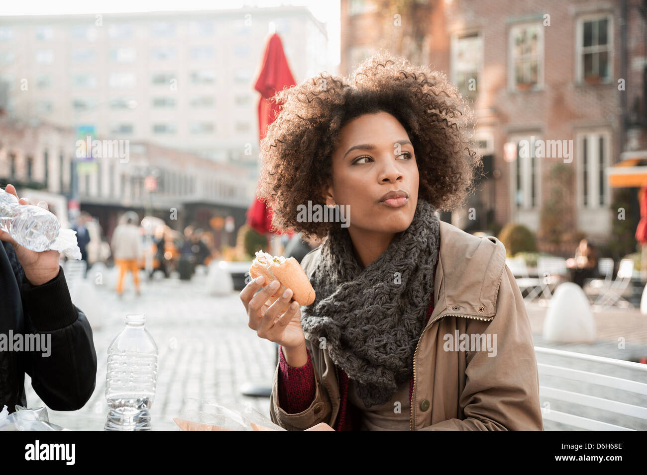 Woman eating on city street Stock Photo - Alamy