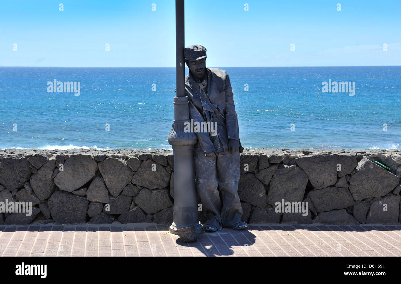 A male street performer leaning against a lamp post in Playa Blanca ...