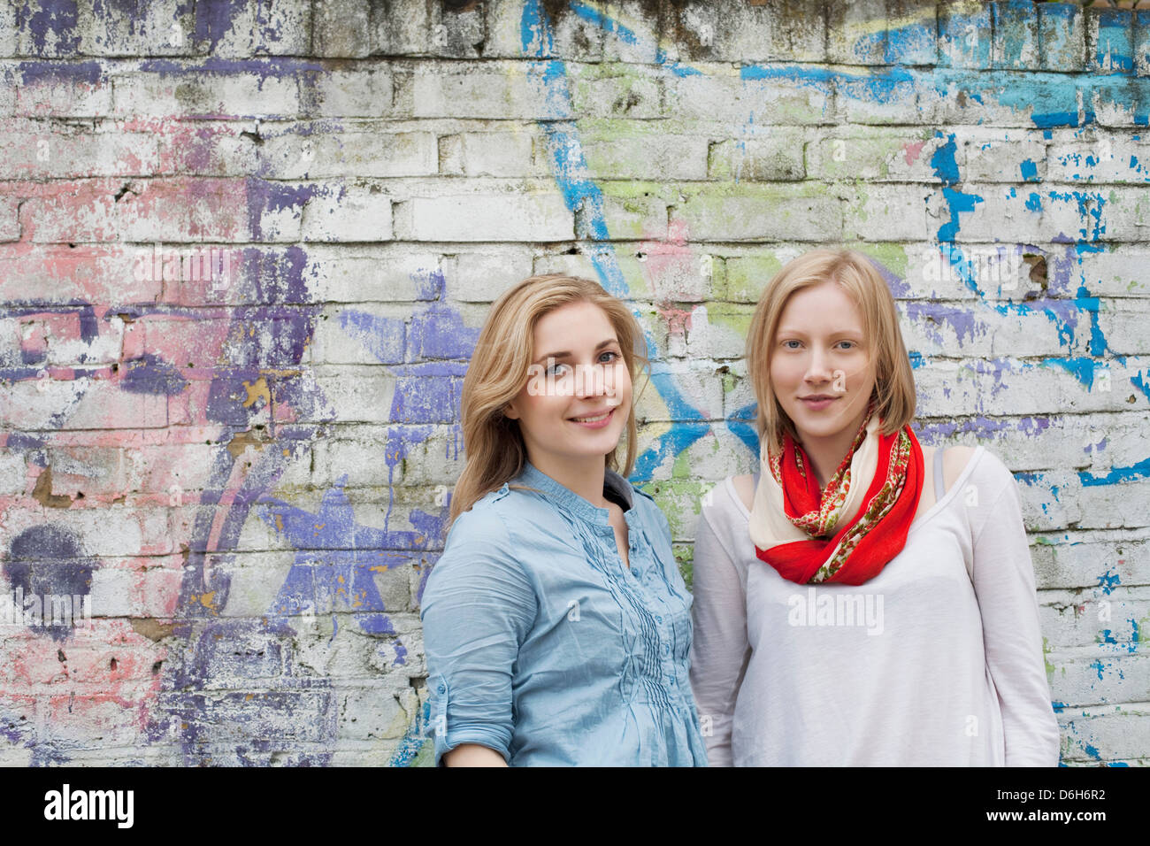 Women smiling by brick wall Stock Photo - Alamy
