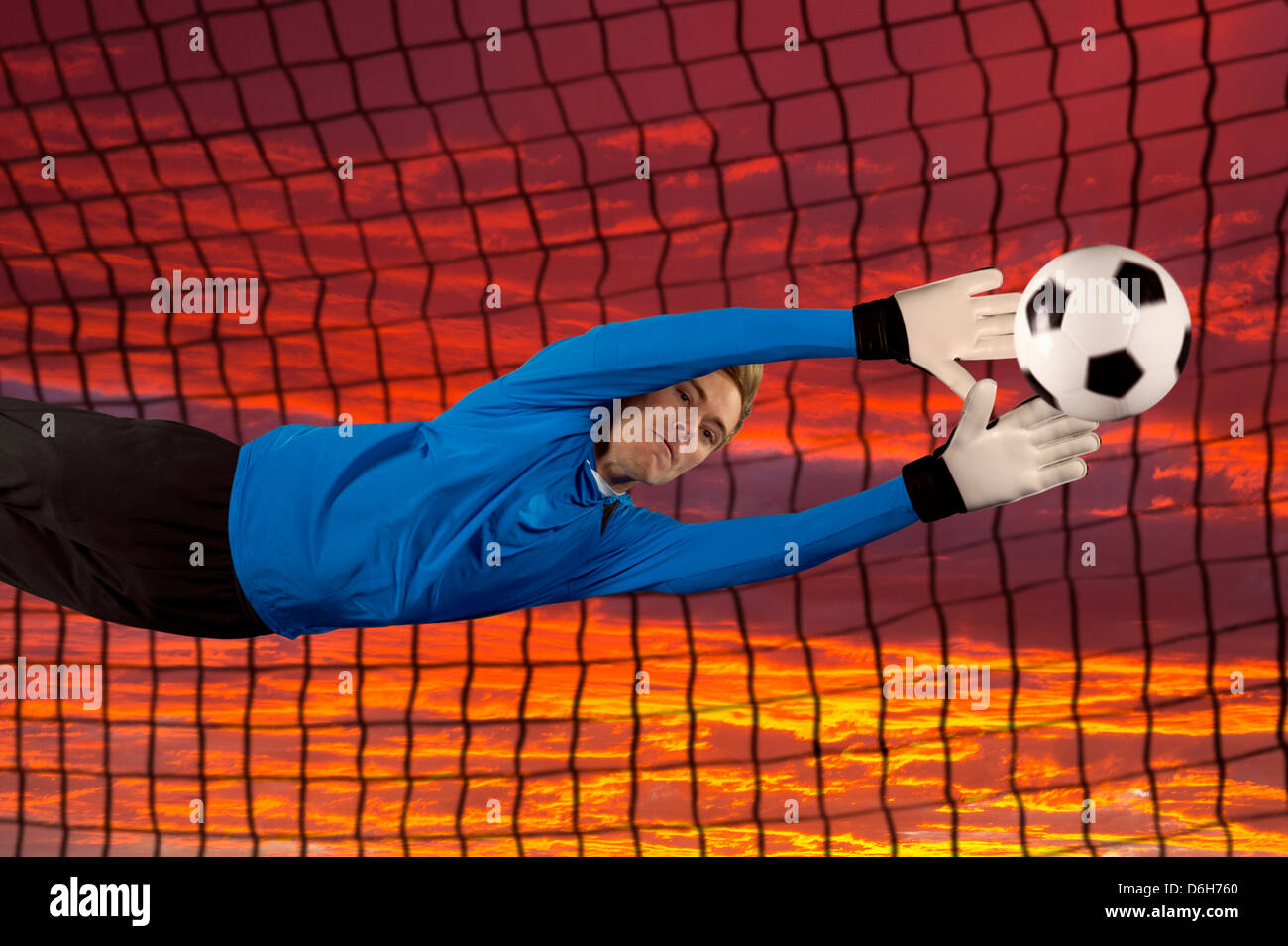 Soccer player deflecting ball in air Stock Photo - Alamy