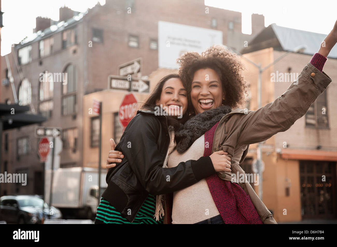 Women hugging on city street Stock Photo - Alamy
