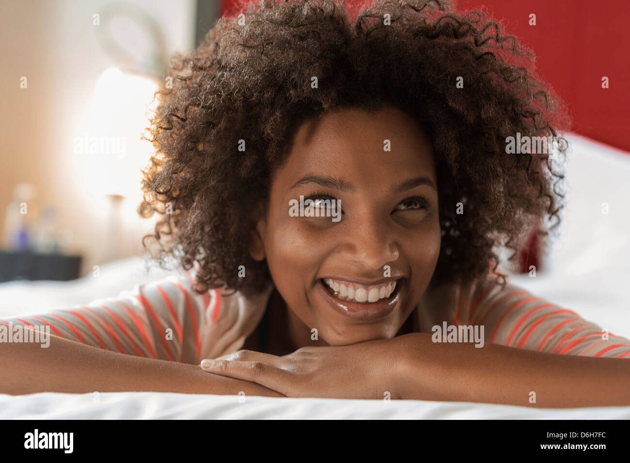 Smiling woman laying on bed Stock Photo - Alamy