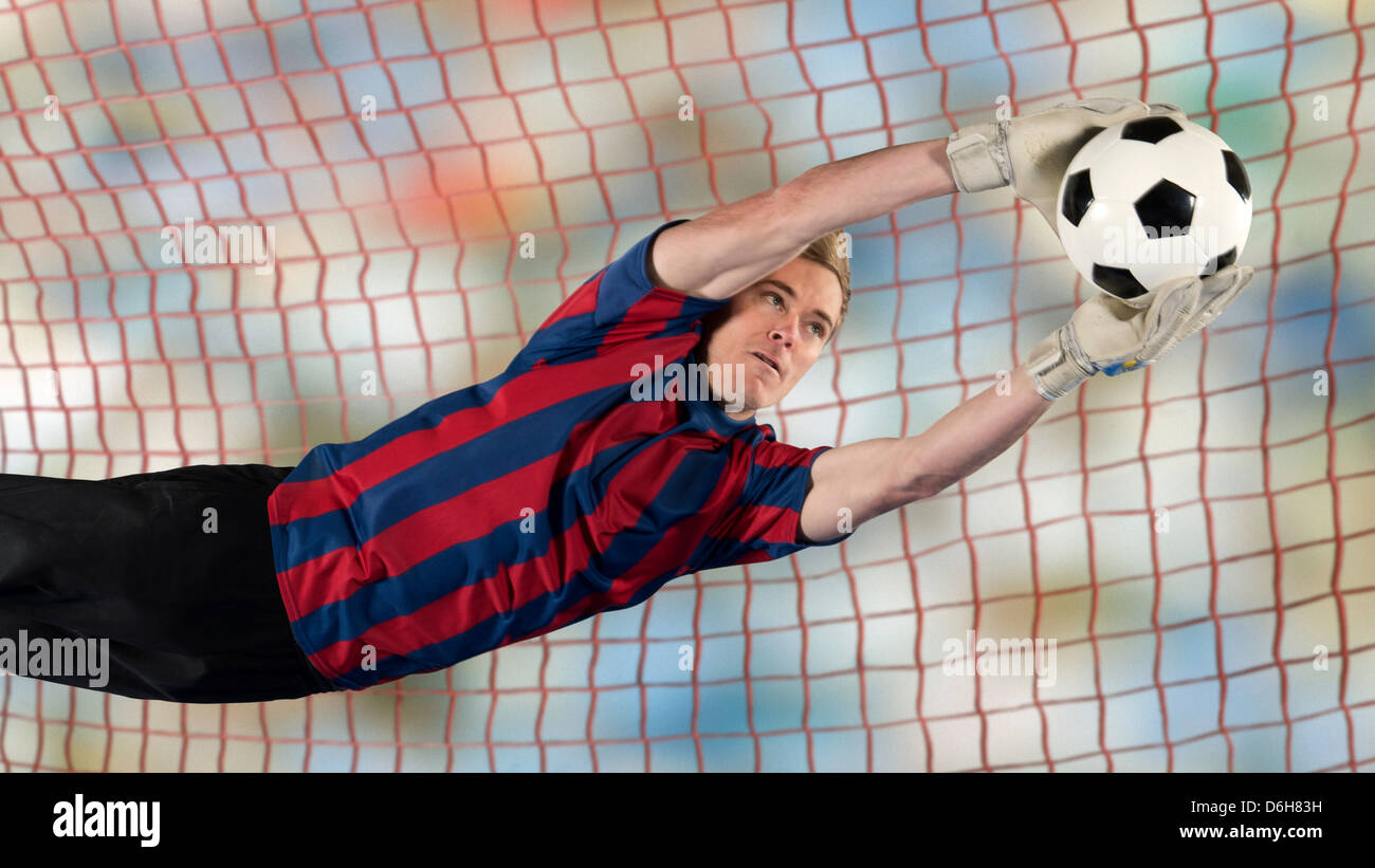Soccer player catching ball in air Stock Photo - Alamy