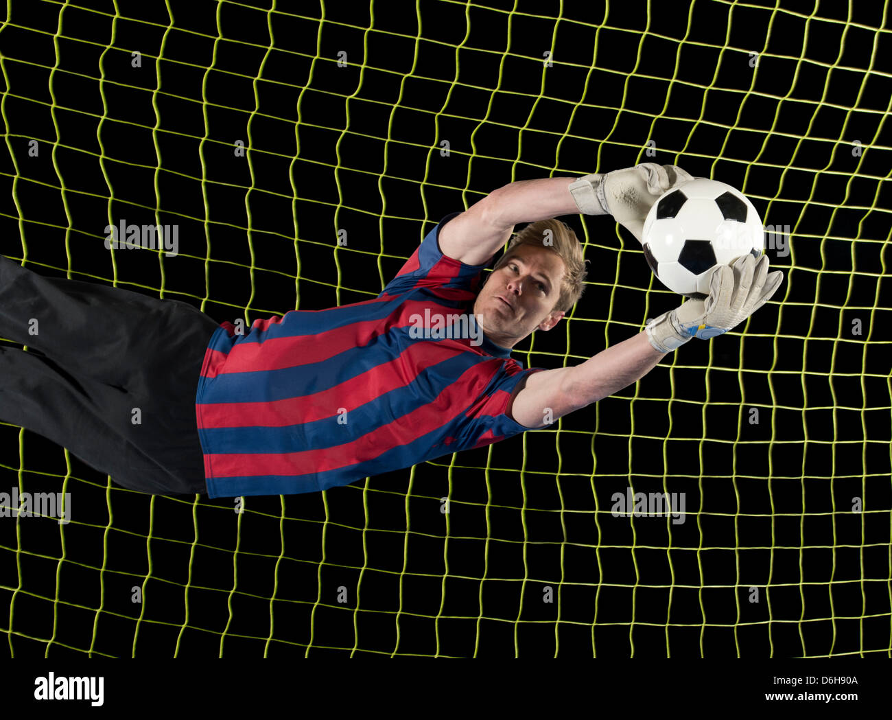 Soccer player catching ball in air Stock Photo - Alamy