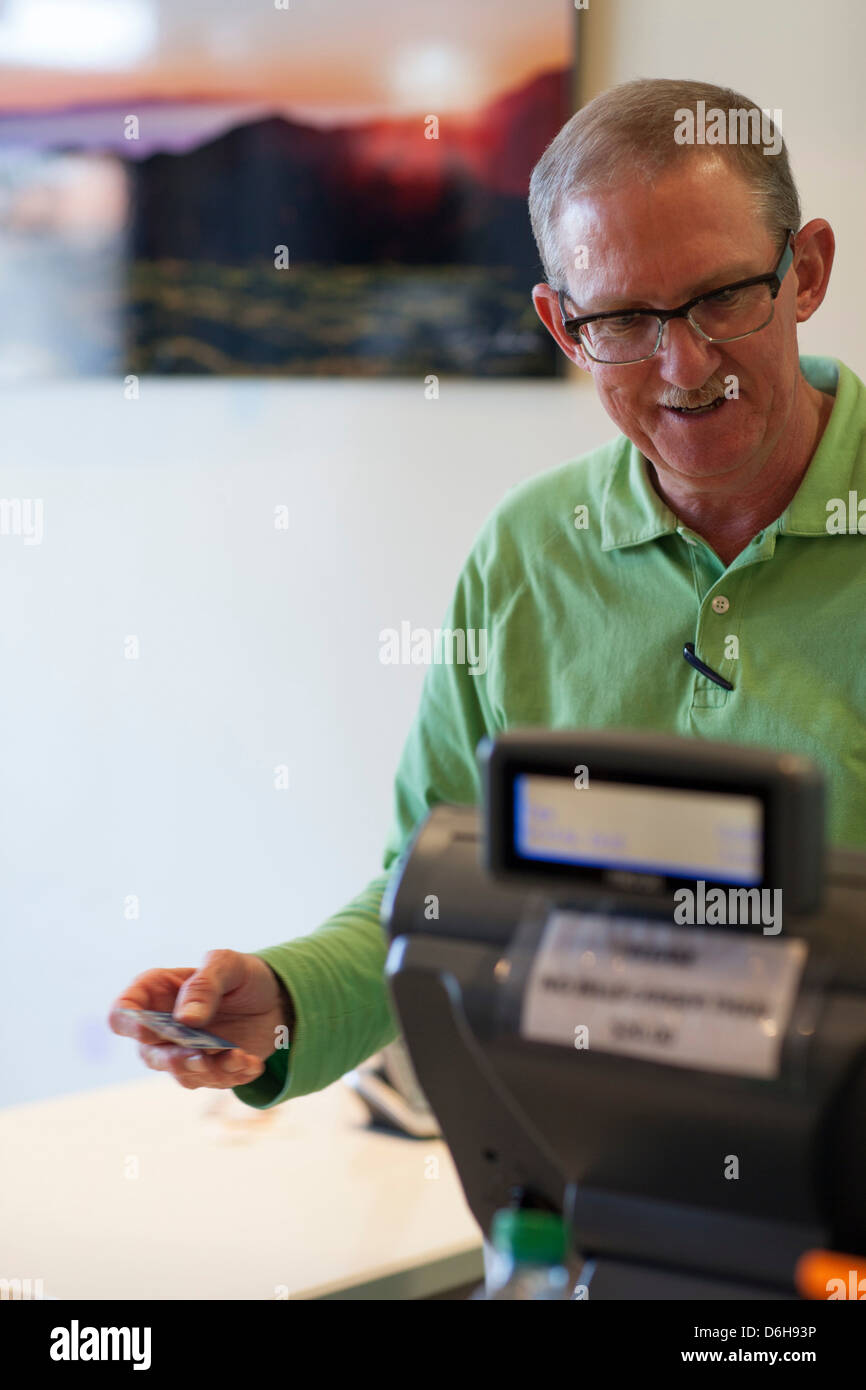 Cashier running credit card in store Stock Photo - Alamy