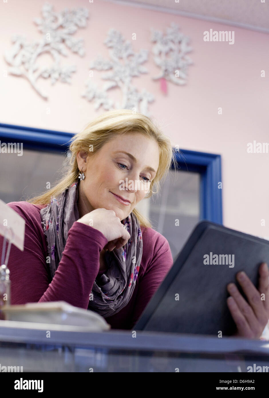 Cashier using tablet computer in store Stock Photo - Alamy