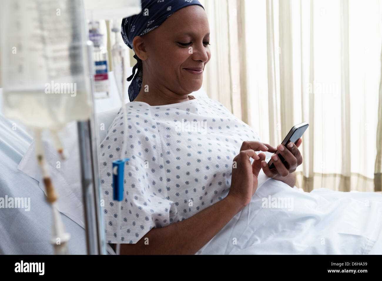Female hospital patient using cellphone Stock Photo - Alamy