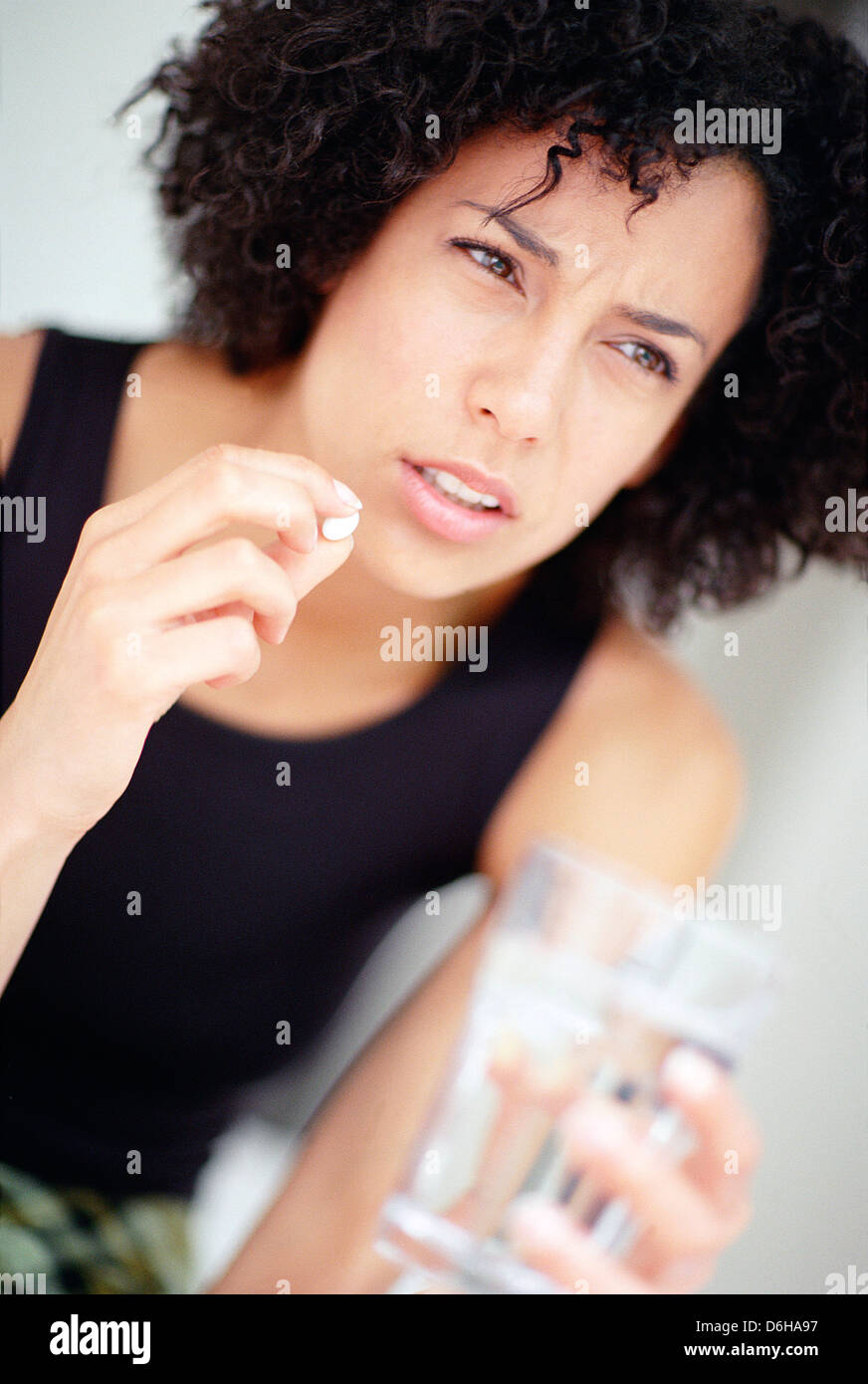 Woman taking a pill Stock Photo - Alamy