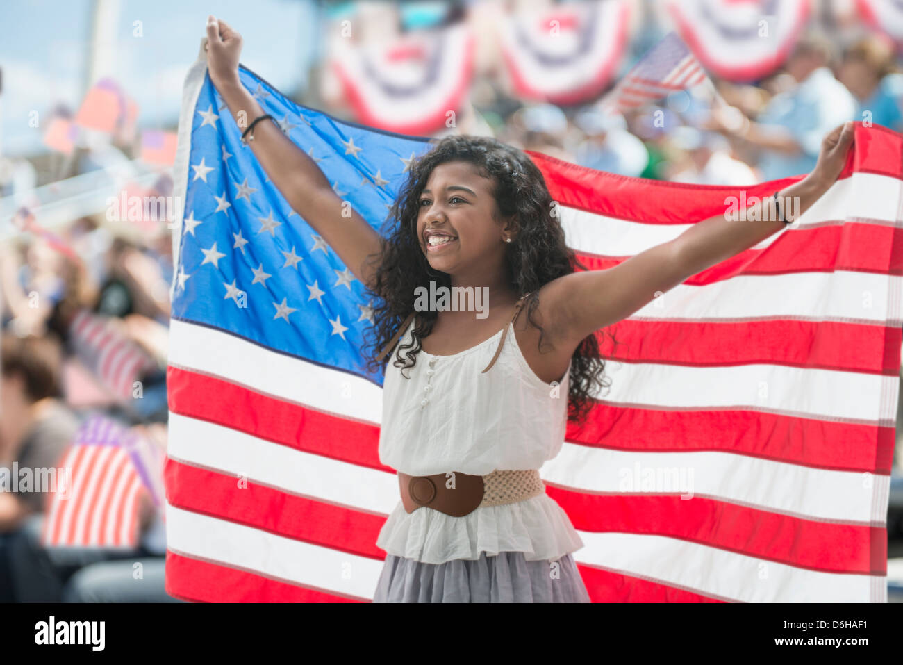 Girl at rally holding up american flag Stock Photo - Alamy