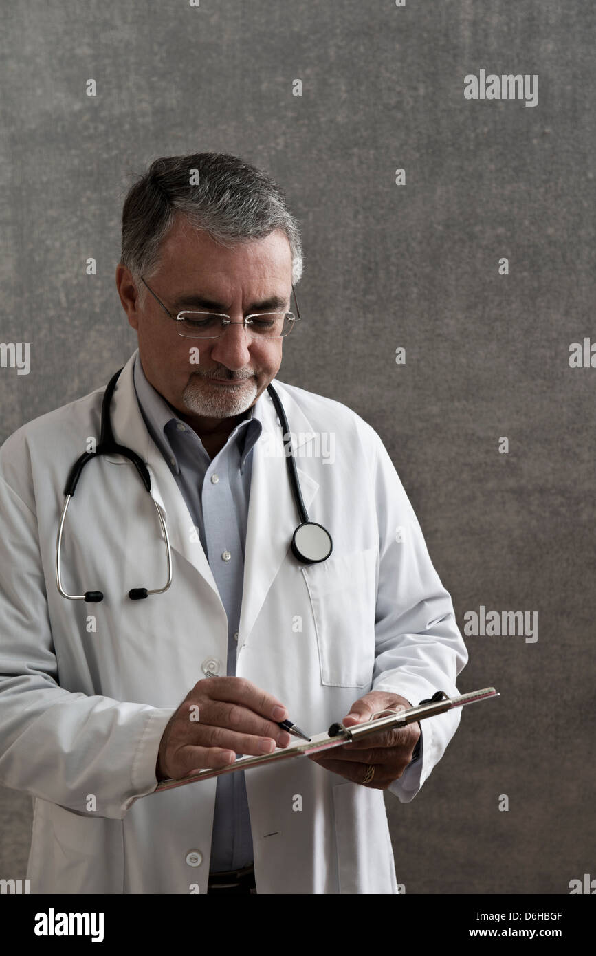 Male doctor writing on chart Stock Photo - Alamy