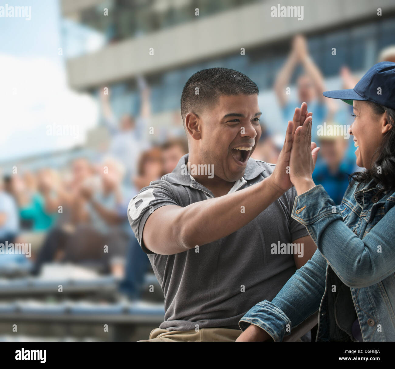 Couple high-fiving at sports game Stock Photo - Alamy