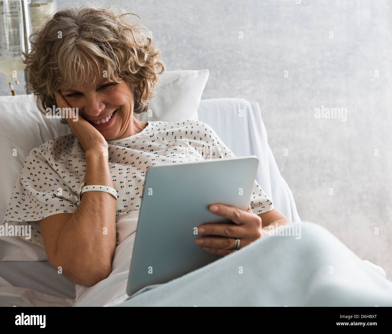 Female hospital patient with digital tablet, smiling Stock Photo - Alamy