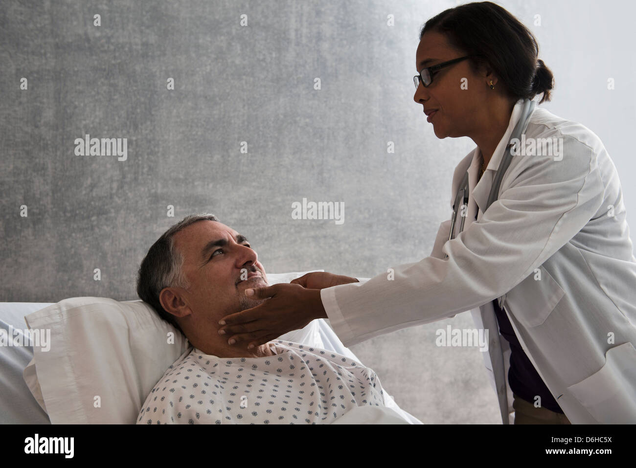 Female doctor checking male patient Stock Photo - Alamy