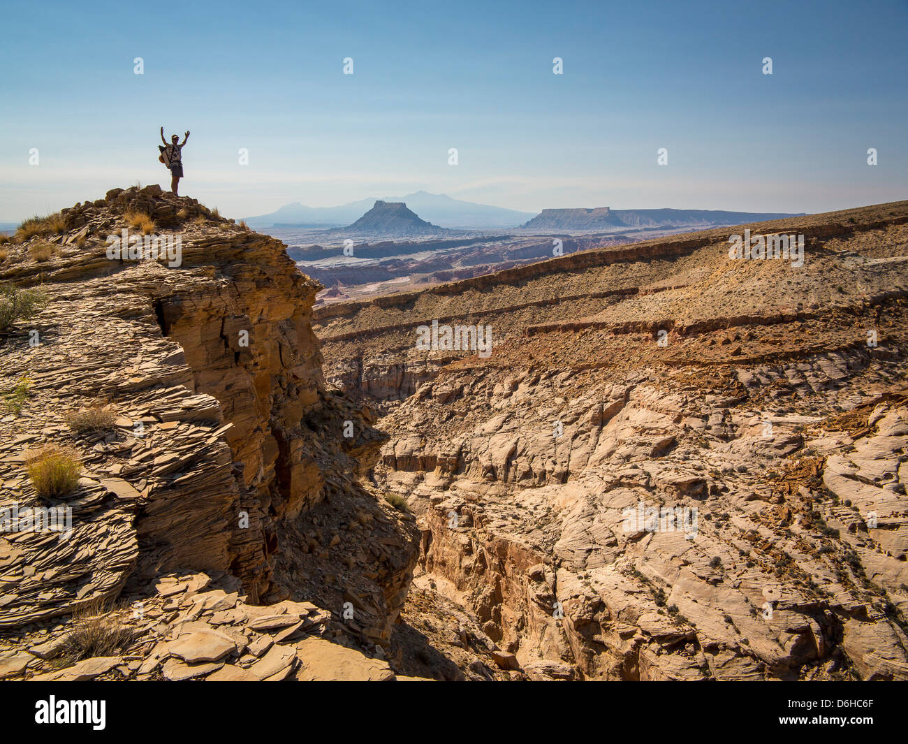 Hiker cheering on rocky hilltop Stock Photo - Alamy