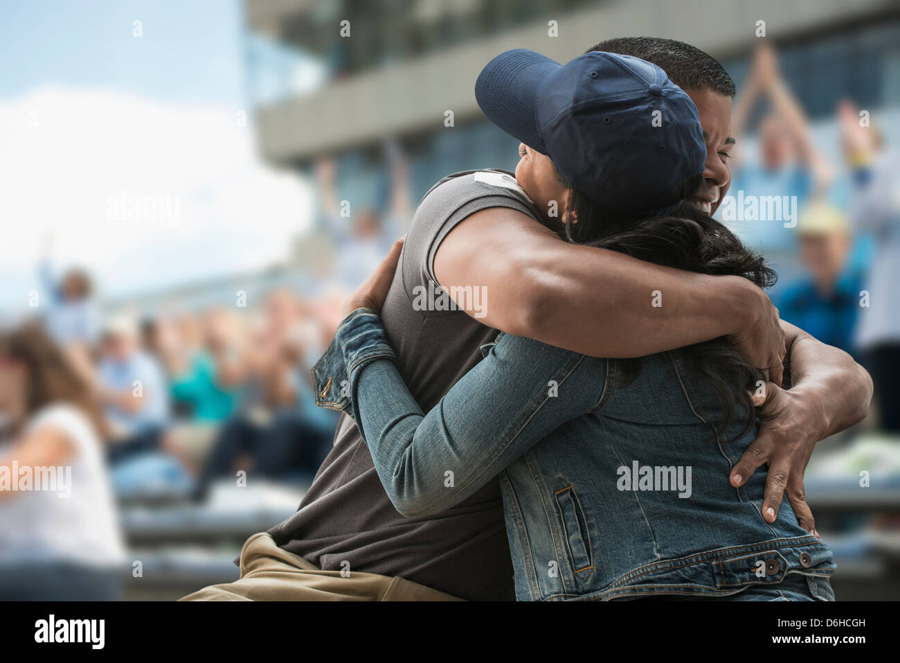 Couple hugging at sports game Stock Photo - Alamy