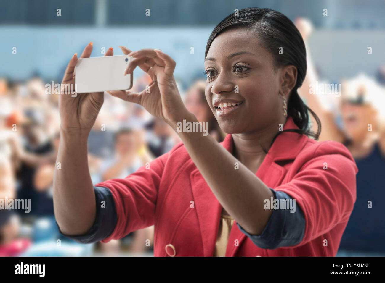 Woman in stadium, recording event with her phone Stock Photo - Alamy