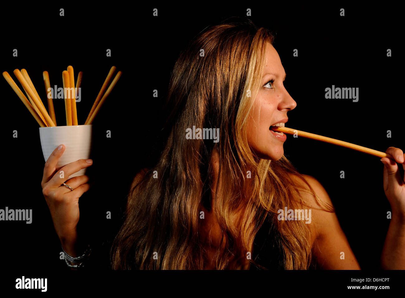 A young Blonde Woman eating Breadsticks Stock Photo - Alamy