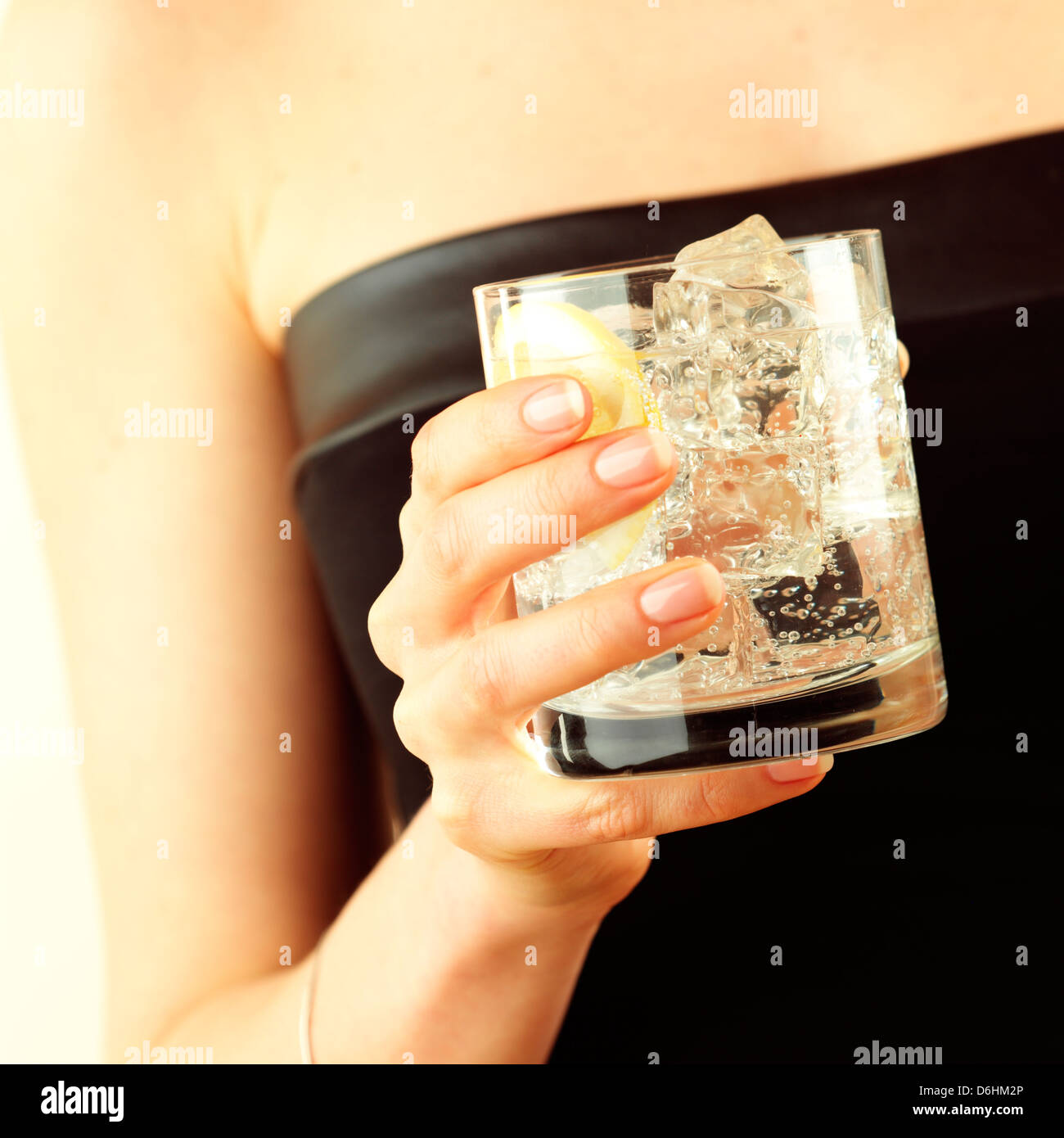 Hand holding a gin and tonic Stock Photo - Alamy