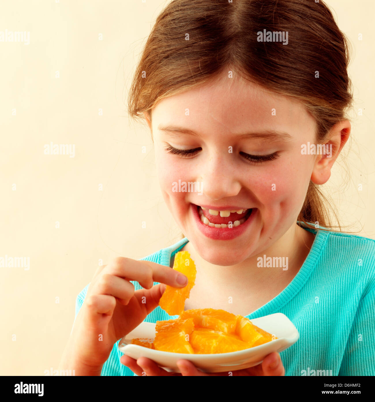 Girl eating orange Stock Photo - Alamy