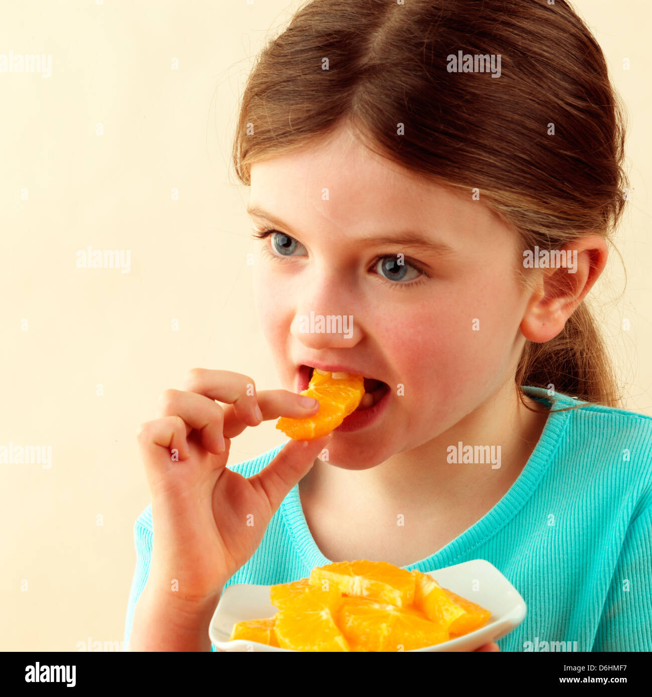 Girl eating orange Stock Photo - Alamy