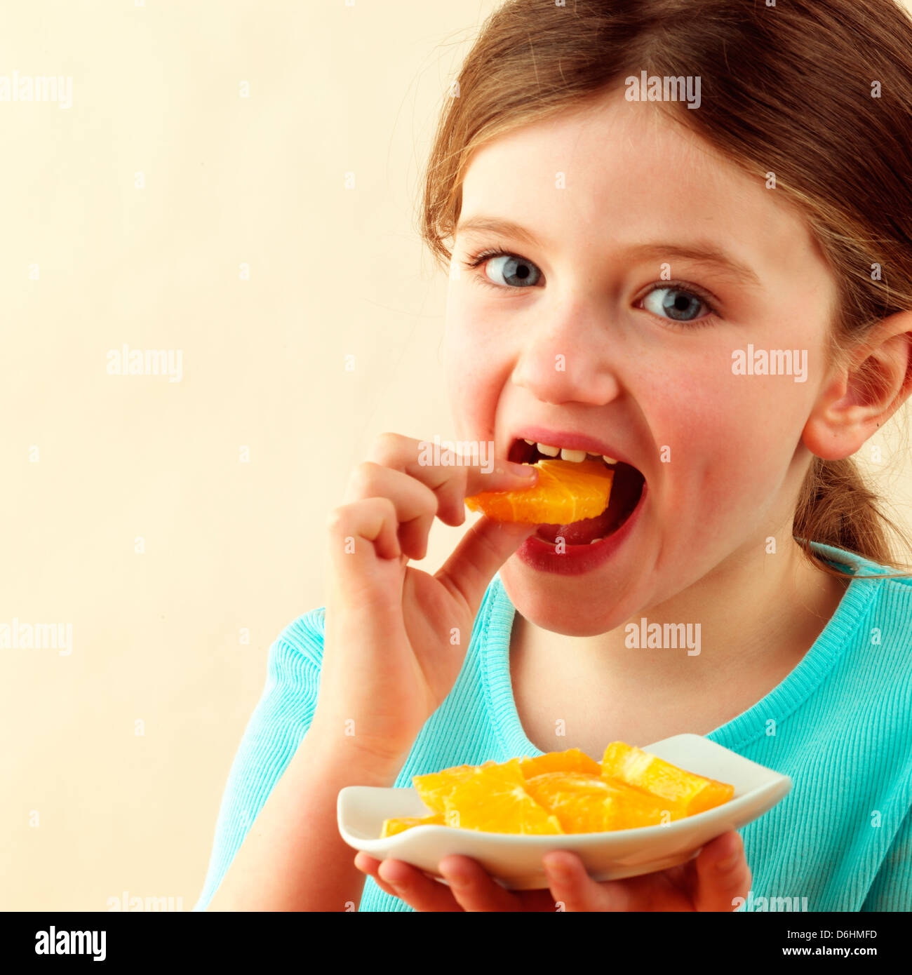 Girl eating orange Stock Photo - Alamy