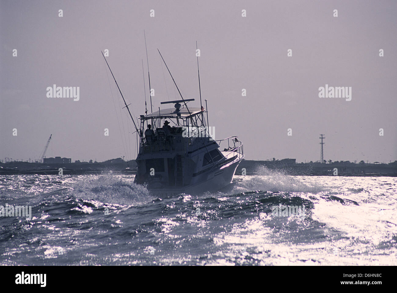 Offshore sport fishing boat running through rough water near the ...