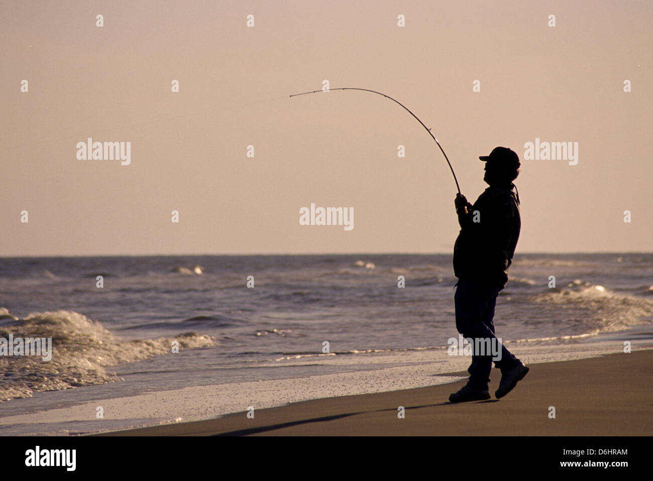 A surf fisherman fighting a fish from the beach on Matagorda Island ...