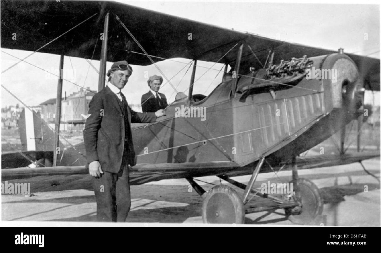 This photo shows a passenger next to a Curtiss JN-4 Jenny biplane at ...