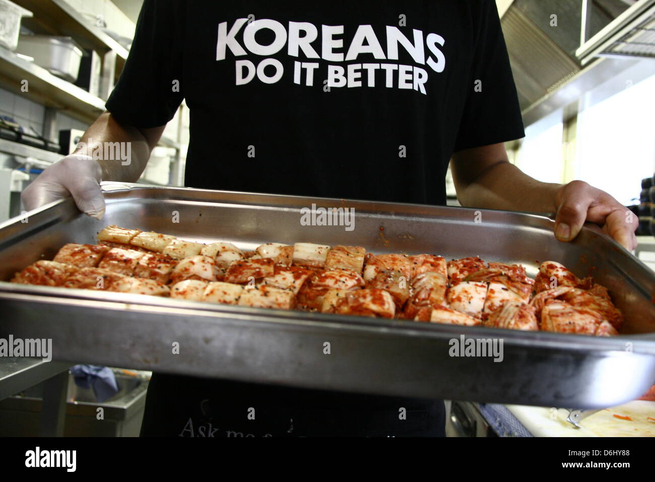 A cook displays spicy cabbage salad, the South Korean national dish ...