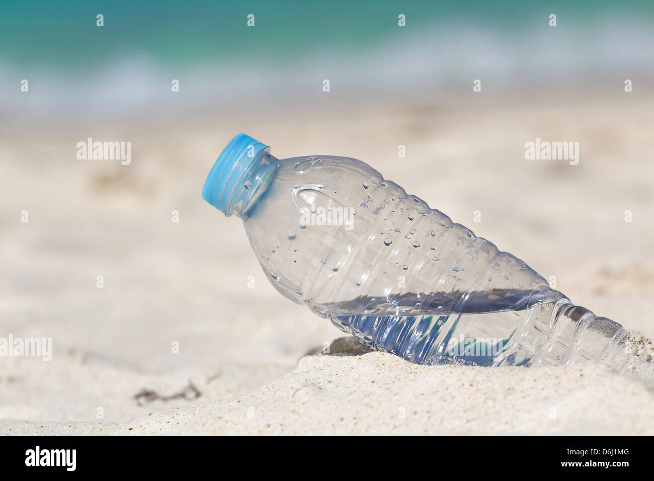 Water in bottle on sand on tropical beach Stock Photo - Alamy
