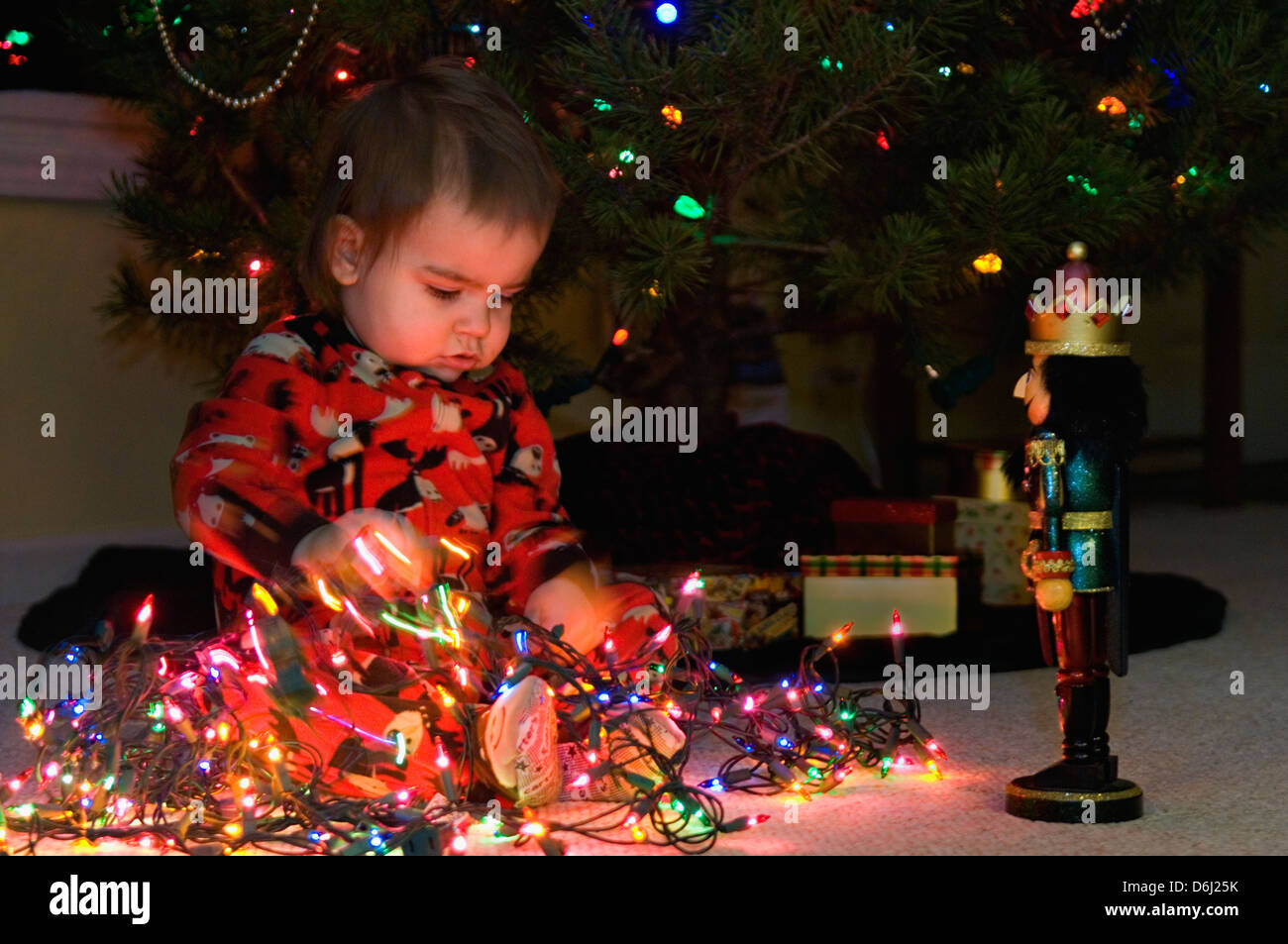Twenty Month Old Boy Playing with Nutcracker beside Christmas Tree ...