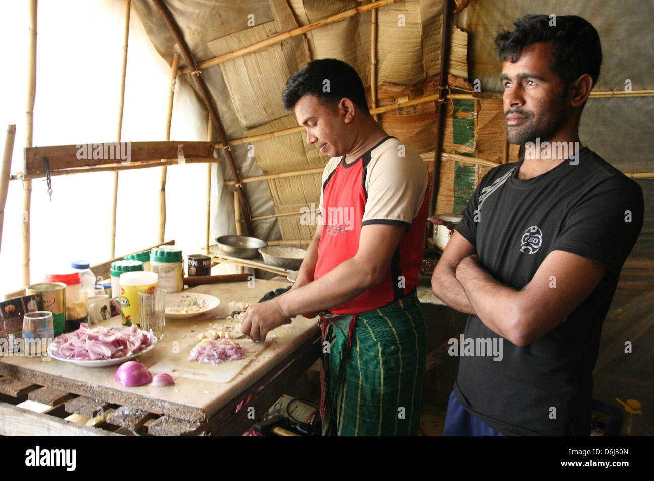 Seasonal harvesters cook food in a barrack near a strawberry field in ...